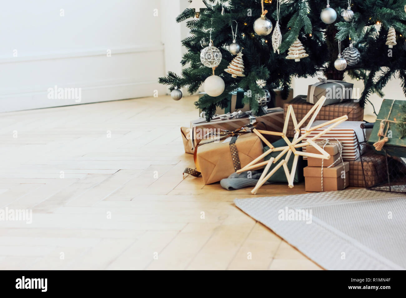 Gifts under decorated Christmas tree, minimalistic Scandinavian decor ...