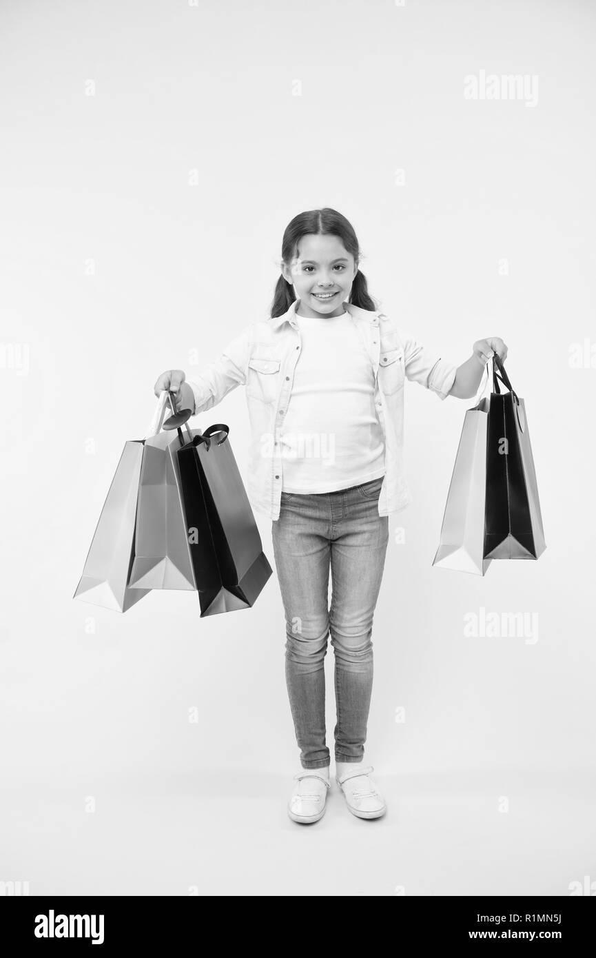 Little helper. Child cute fashionista helps carry packages during ...