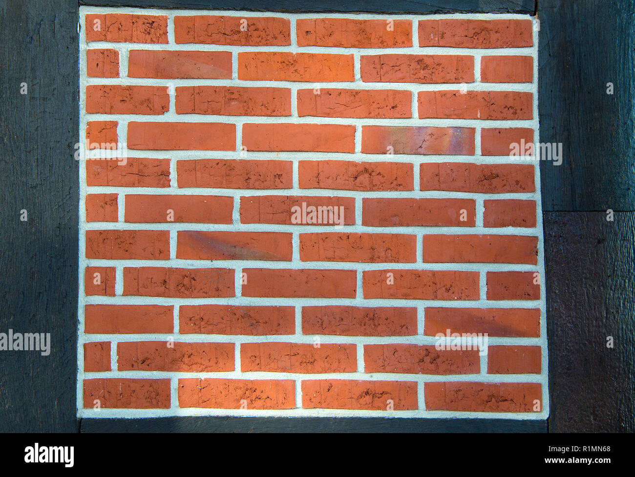 Brickwork of red bricks on wooden wall on black background. Defense ...