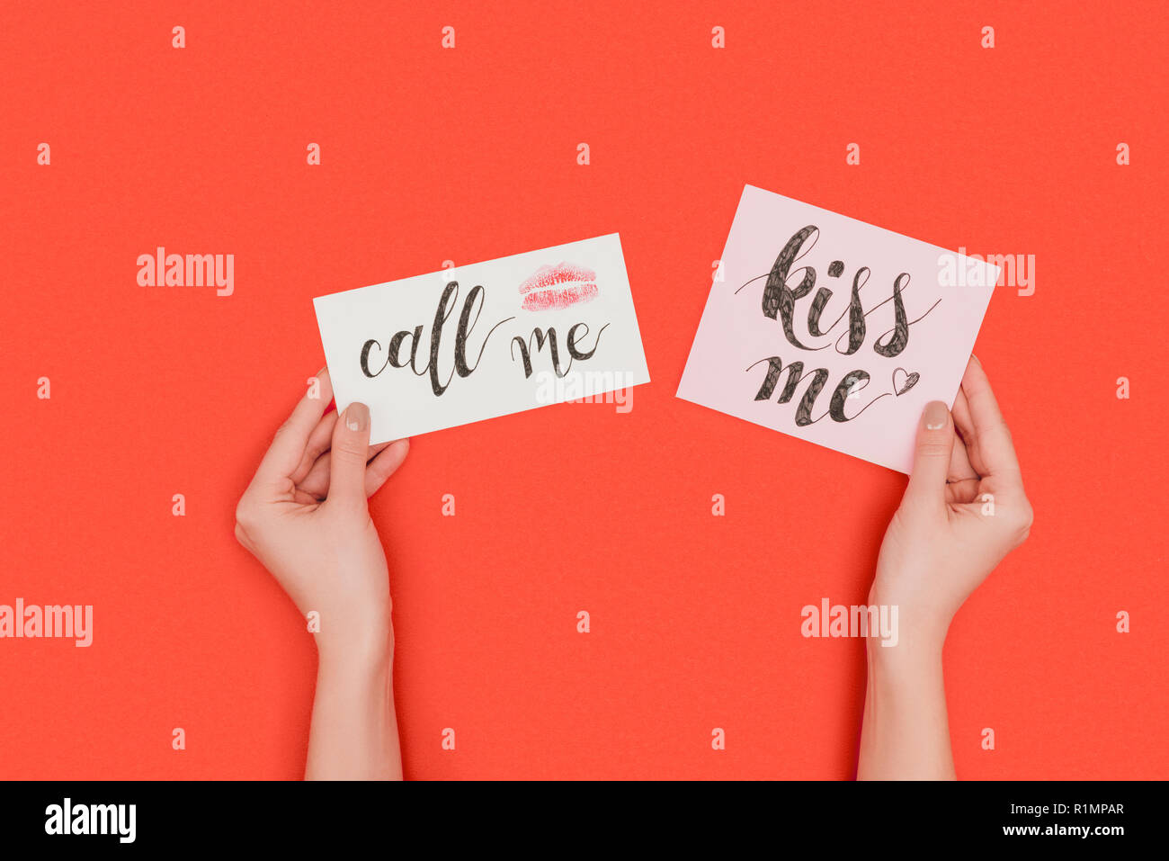 partial top view of person holding cards with kiss me and call me ...