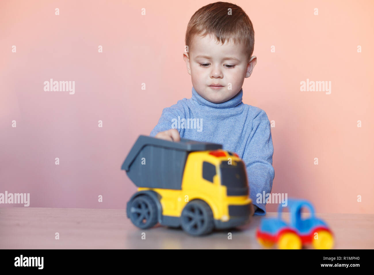 A cute little boy playing with model car collection. Toy mess in child ...
