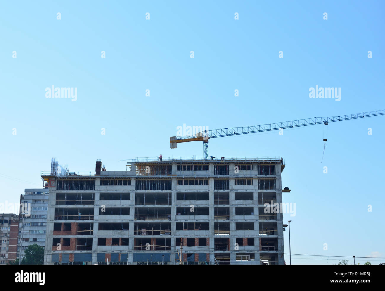 Building under construction with a crane in a city area Stock Photo - Alamy