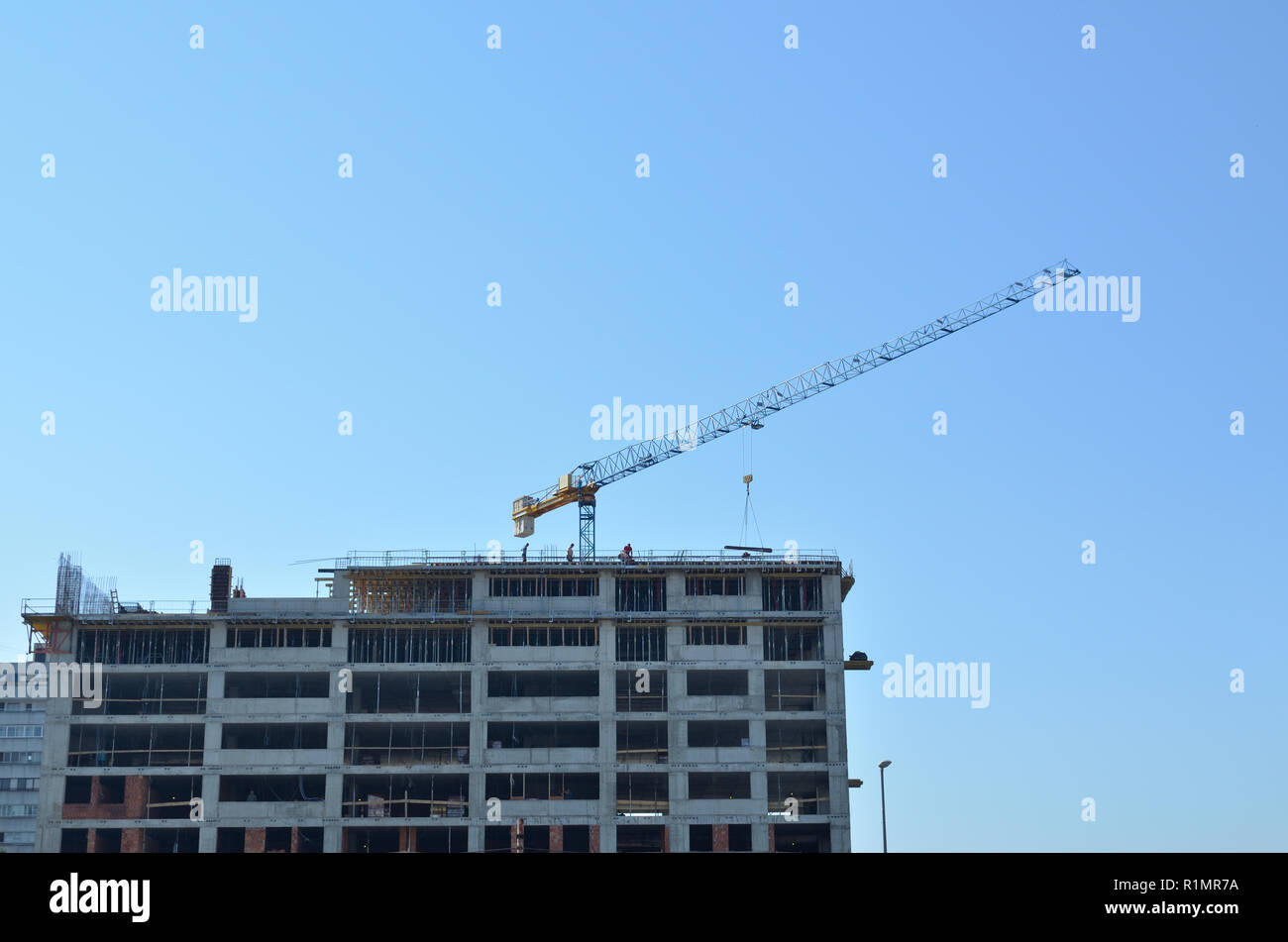 Building during construction works in a city area, with a crane against ...