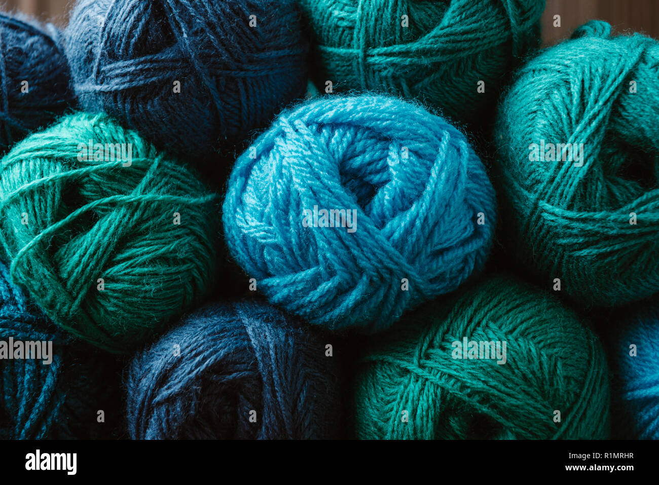 full frame of blue and green yarn balls for knitting as background ...