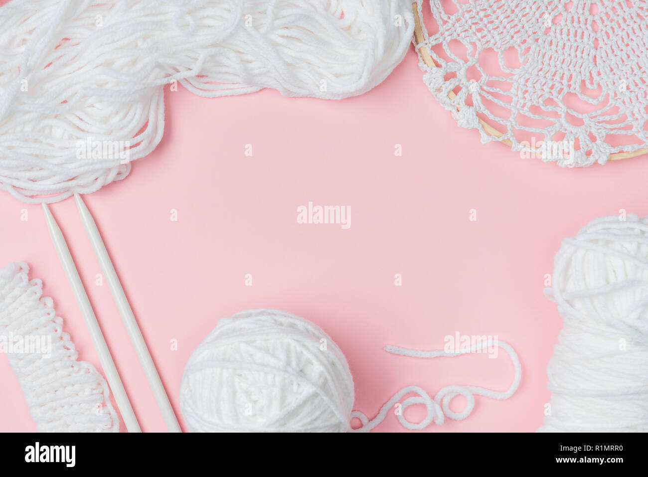 top view of white yarn and knitting needles on pink backdrop Stock ...