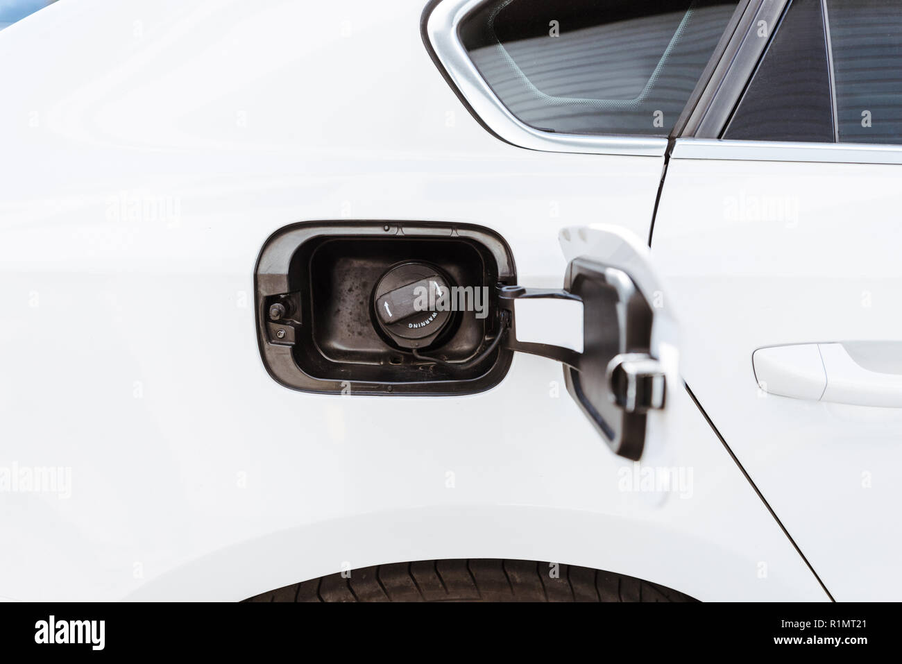 cropped image of open car tank cover on white car Stock Photo - Alamy