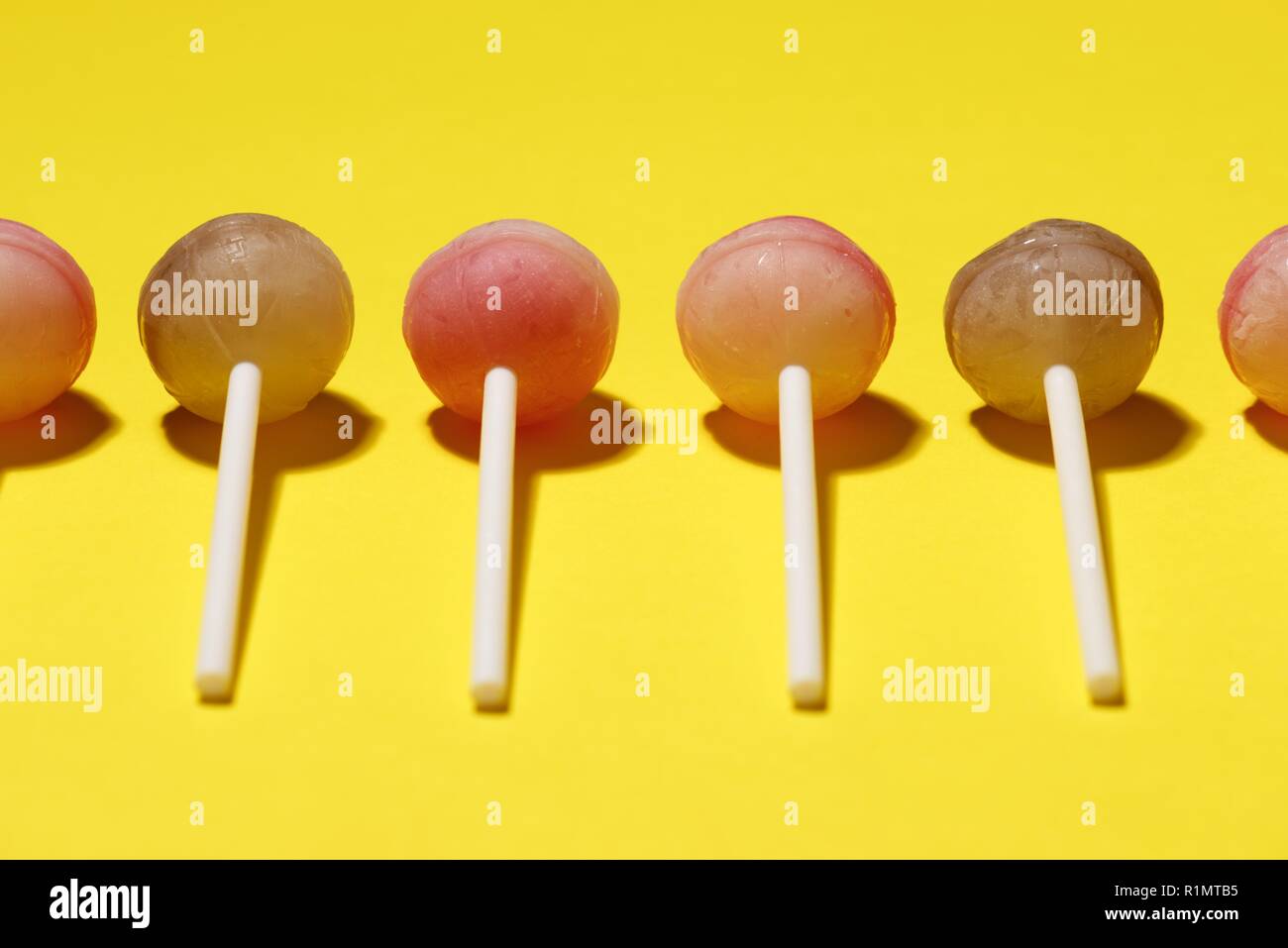 Ball lollipops on a yellow background Stock Photo - Alamy