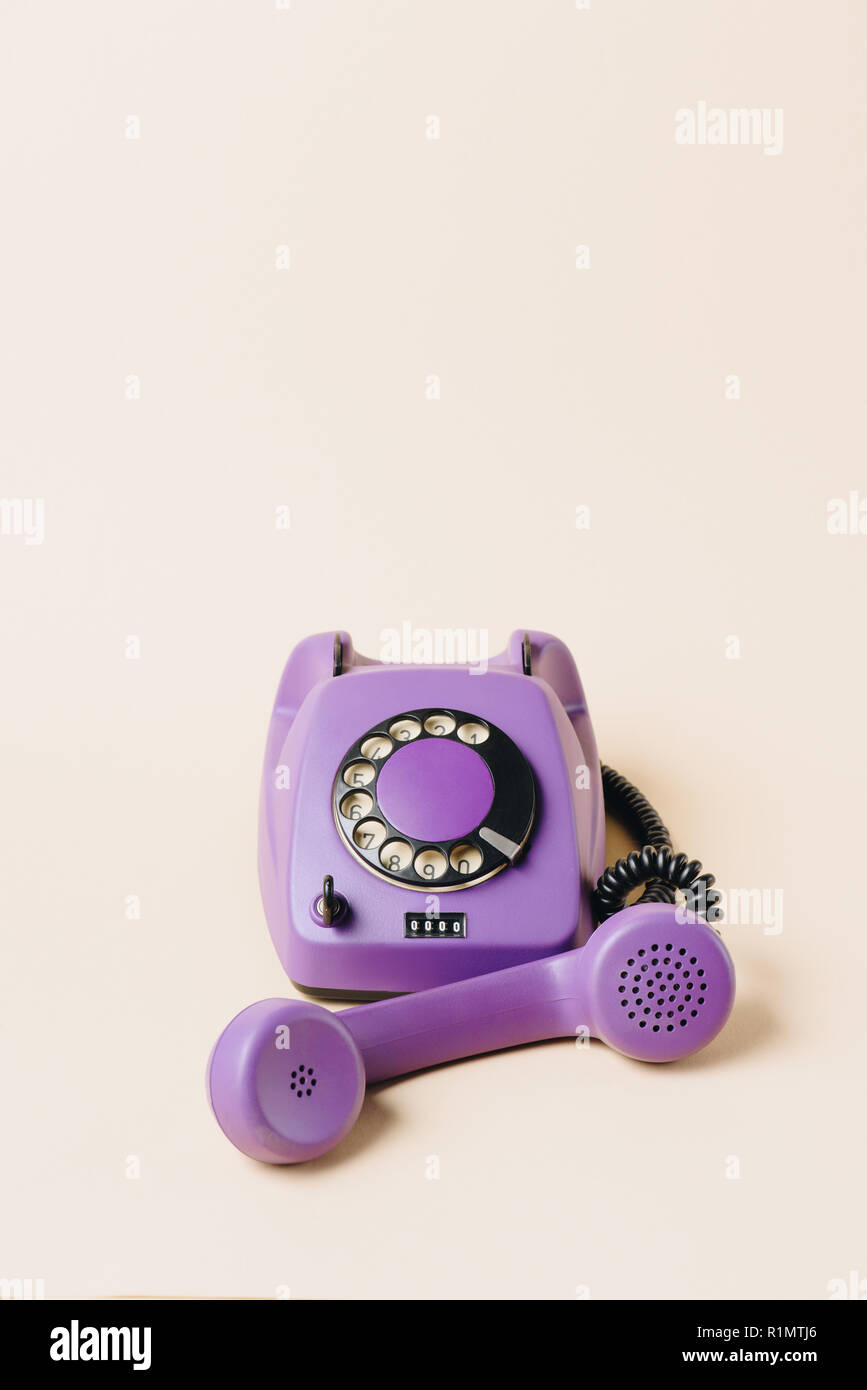 purple vintage rotary telephone with tube on beige Stock Photo - Alamy