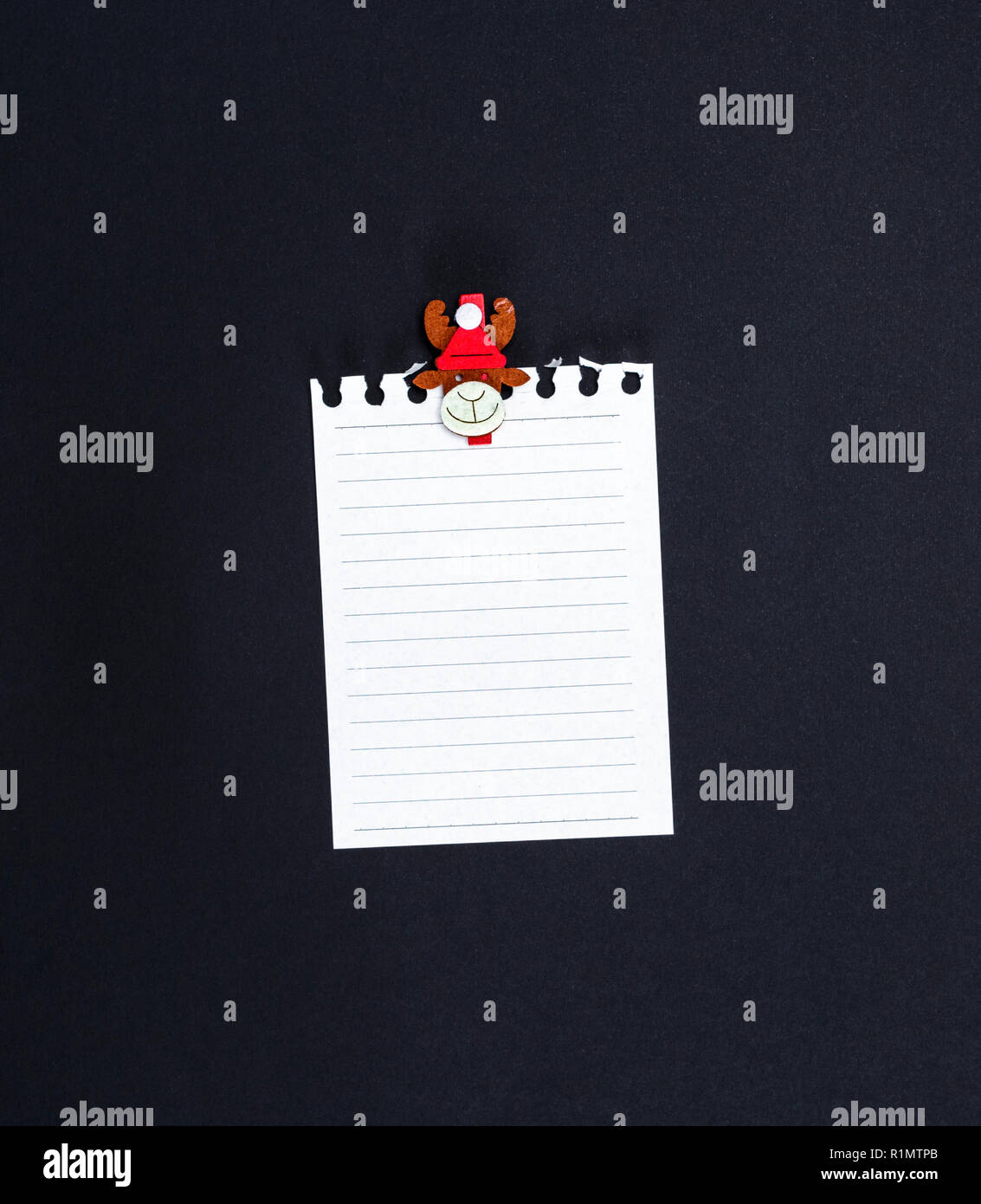 white blank sheet in a line torn out of notepad on a black background ...