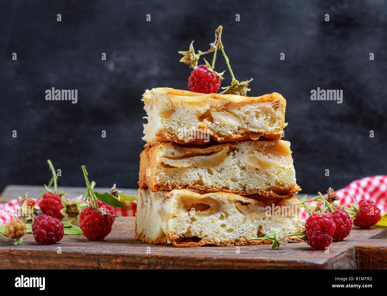 pieces of apple pie are stacked on a brown wooden board, sponge cake ...
