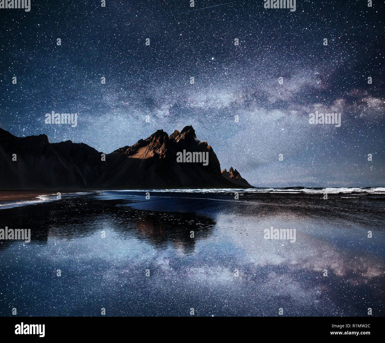 Amazing mountains reflected in the water at starry night. Stoksnes ...