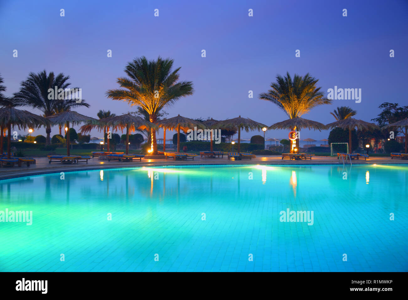 tropical resort pool at sunset Stock Photo - Alamy