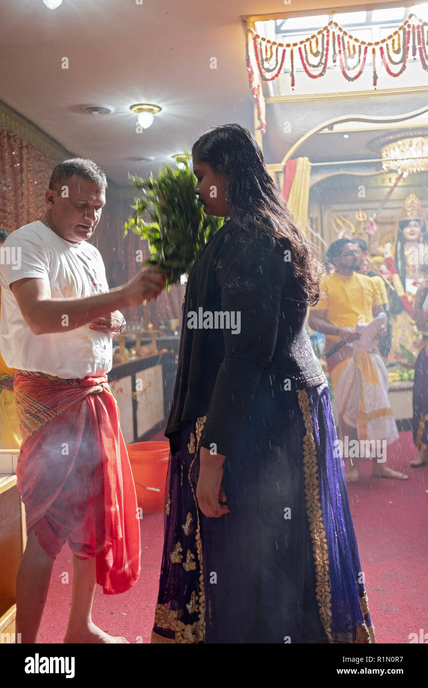 A Hindu devotee gets a cleansing and blessing at a Shakti Hindu temple ...