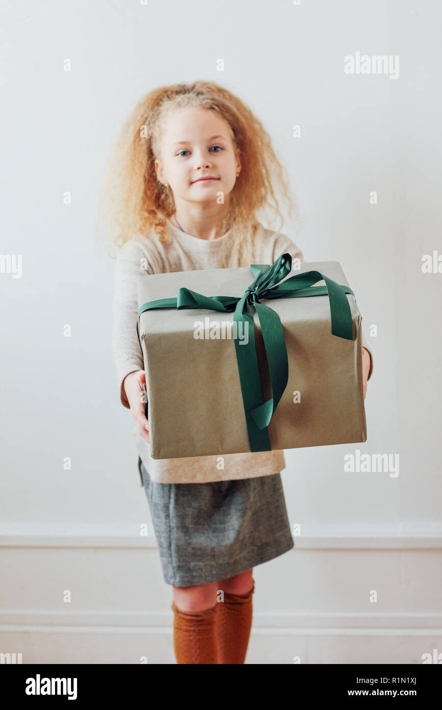 Pretty little girl holding big gift box Stock Photo - Alamy