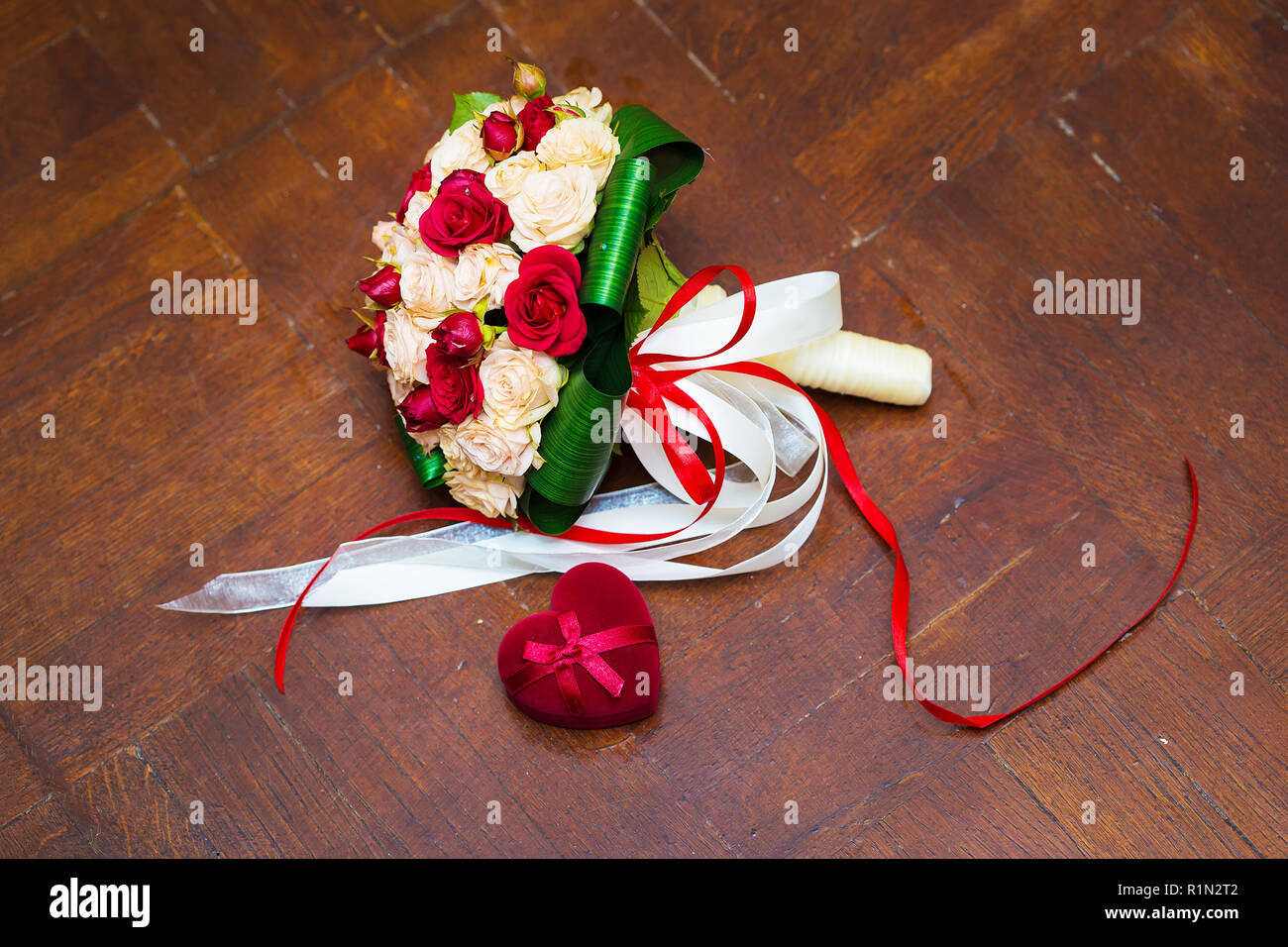 Wedding bouquet of red and cream roses lying on wooden floor Stock ...