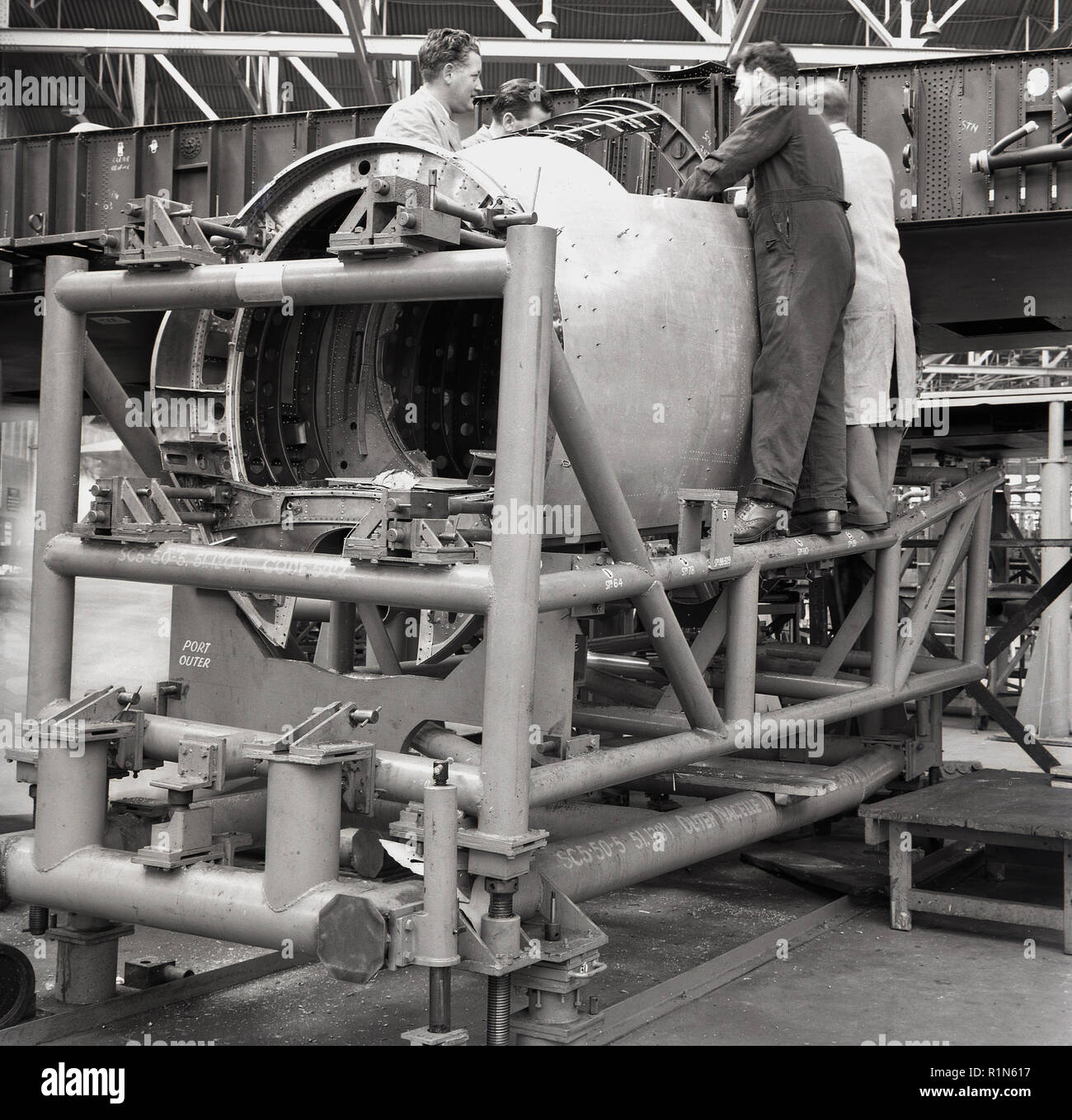1960s, aviation, aircraft manufacture, in a large hangar, male workers ...