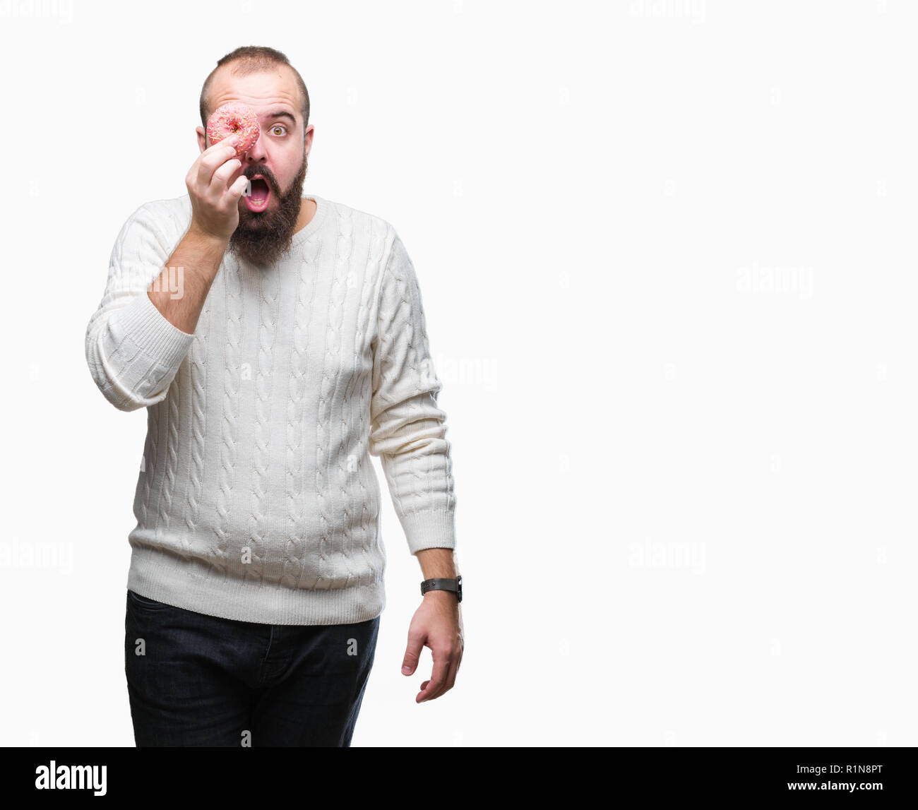 Young caucasian hipster man eating sweet donut over isolated background ...
