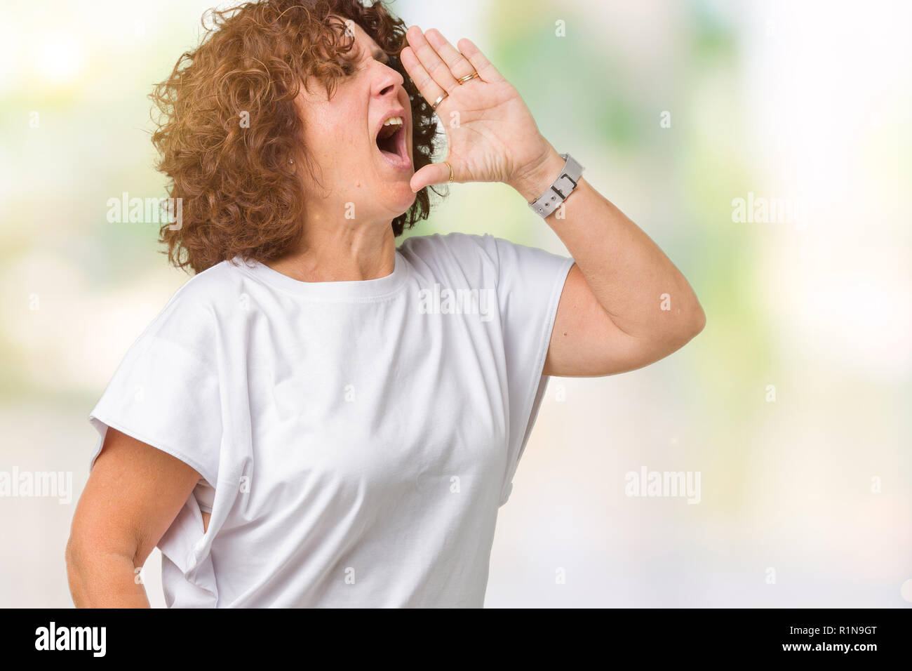 Beautiful middle ager senior woman wearing white t-shirt over isolated ...