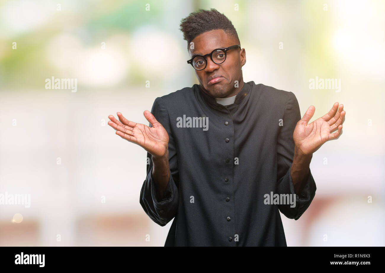 Young african american priest man over isolated background clueless and ...