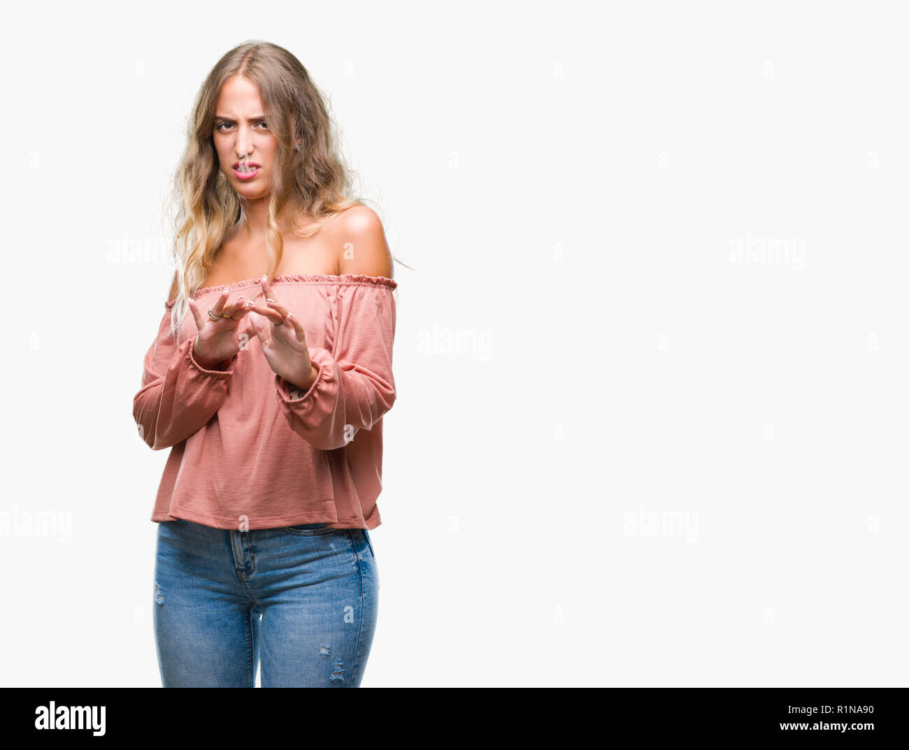 Beautiful young blonde woman over isolated background disgusted ...