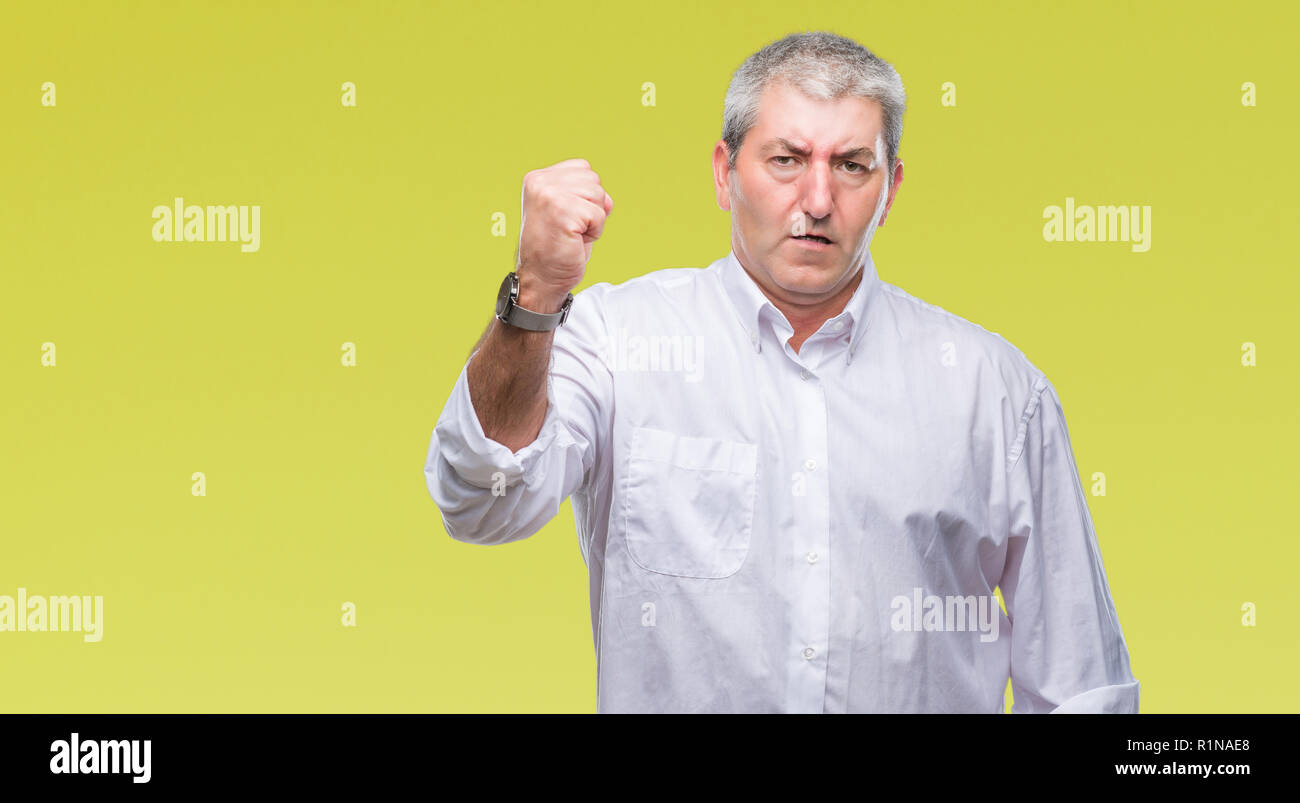 Handsome senior man over isolated background angry and mad raising fist ...