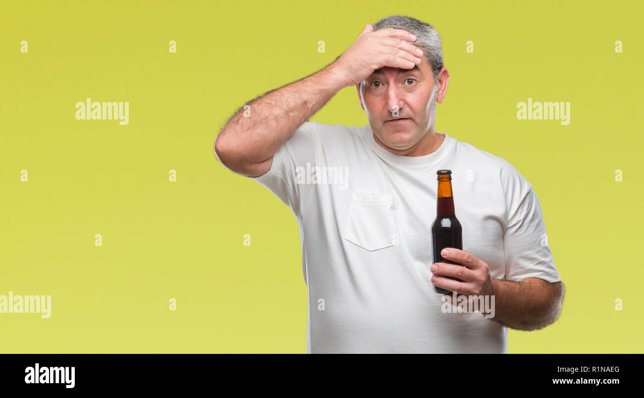 Handsome senior man drinking beer bottle over isolated background ...