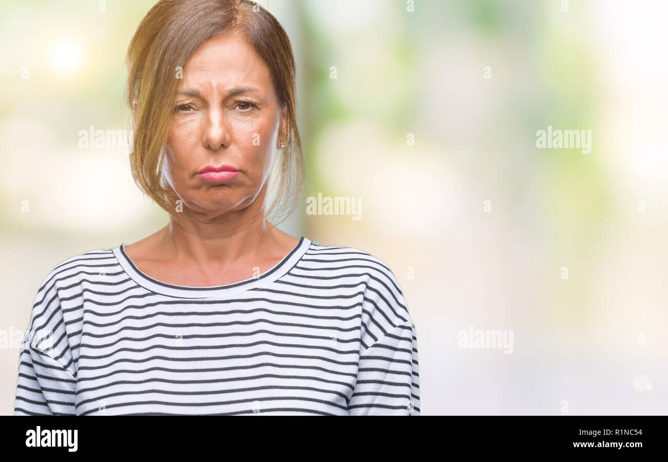 Middle age senior hispanic woman over isolated background depressed and ...