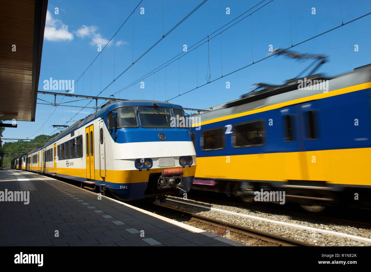A waiting sprinter train and a passing intercity train at the railway ...
