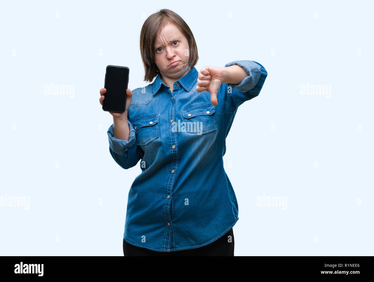 Young adult woman with down syndrome showing smartphone screen over ...