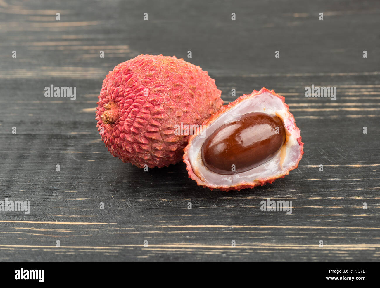 Lychee fruit in-shell half on wooden background Stock Photo - Alamy