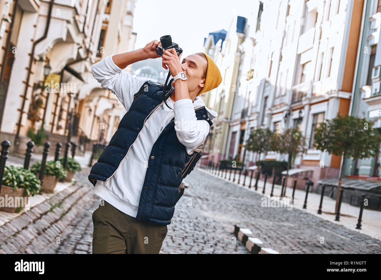 Man tourist with a camera in historical old city. Free casual style ...