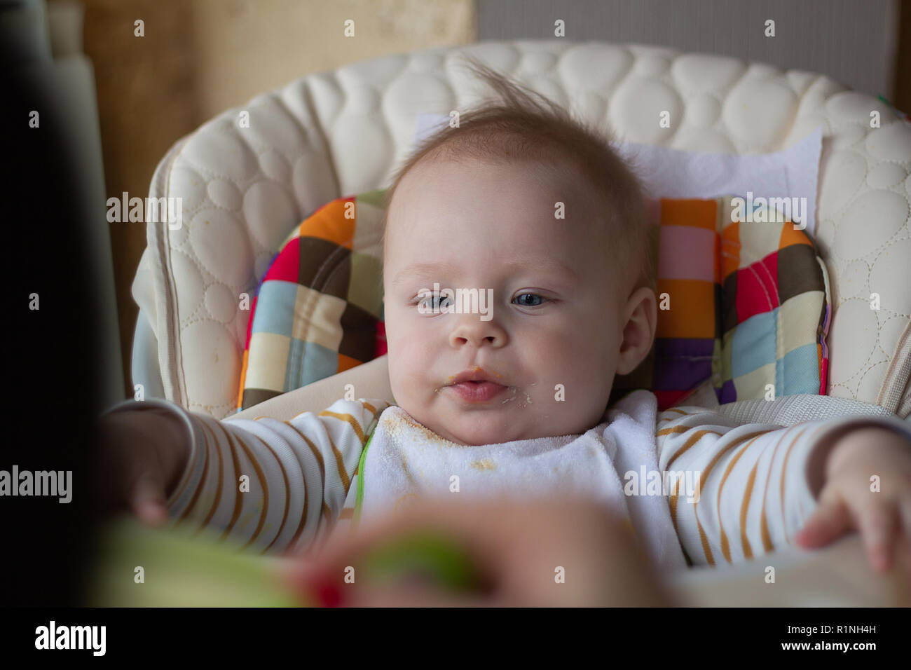 The first feeding of the baby from the spoon. Mom feeds baby ...
