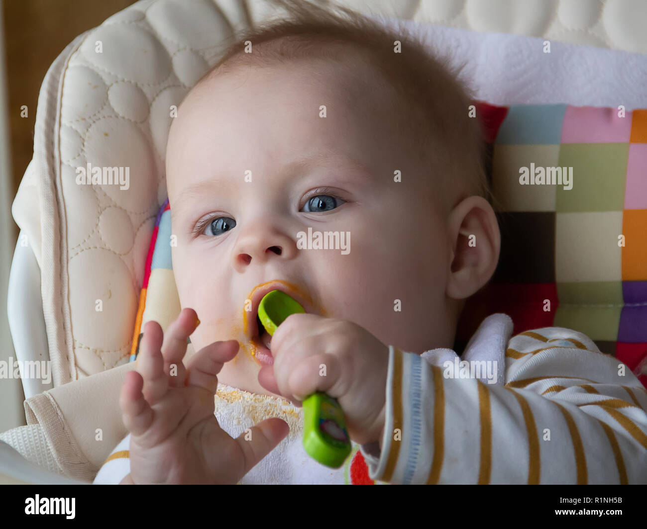 The first feeding of the baby from the spoon. Mom feeds baby ...