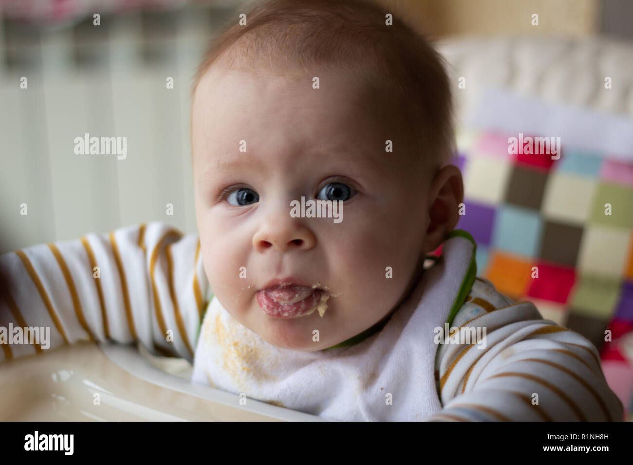 The first feeding of the baby from the spoon. Mom feeds baby ...