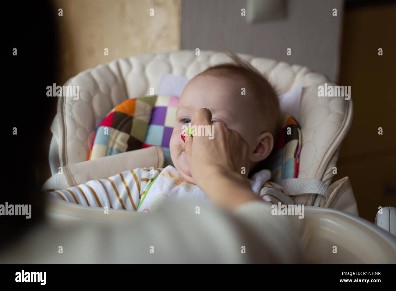 The first feeding of the baby from the spoon. Mom feeds baby ...