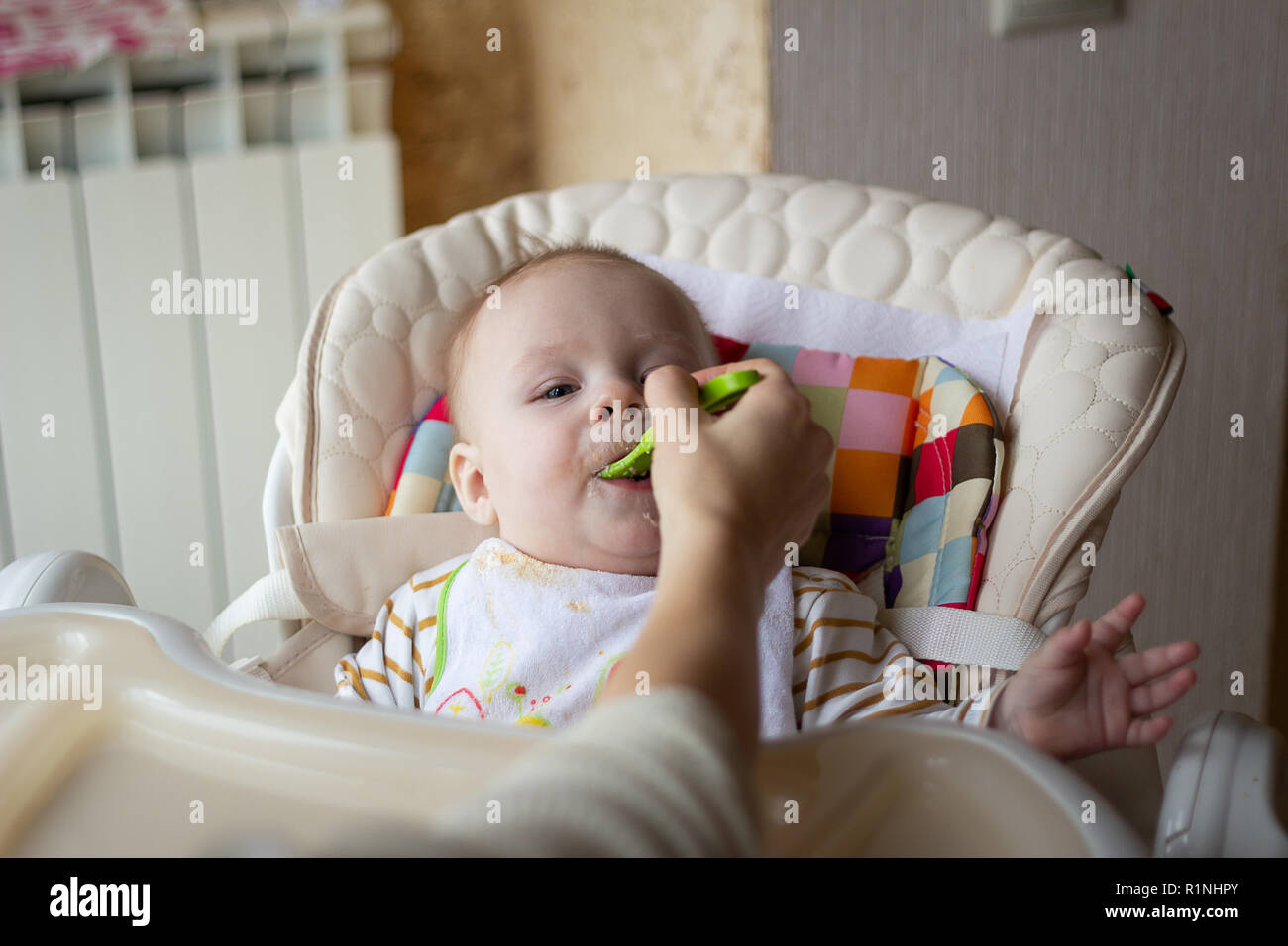 The first feeding of the baby from the spoon. Mom feeds baby ...