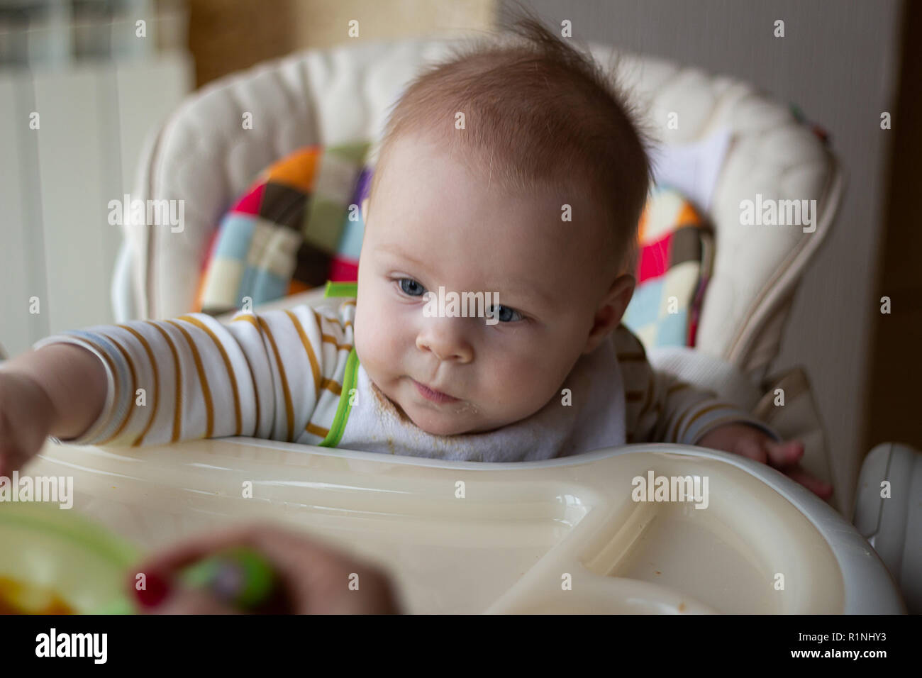 The first feeding of the baby from the spoon. Mom feeds baby ...
