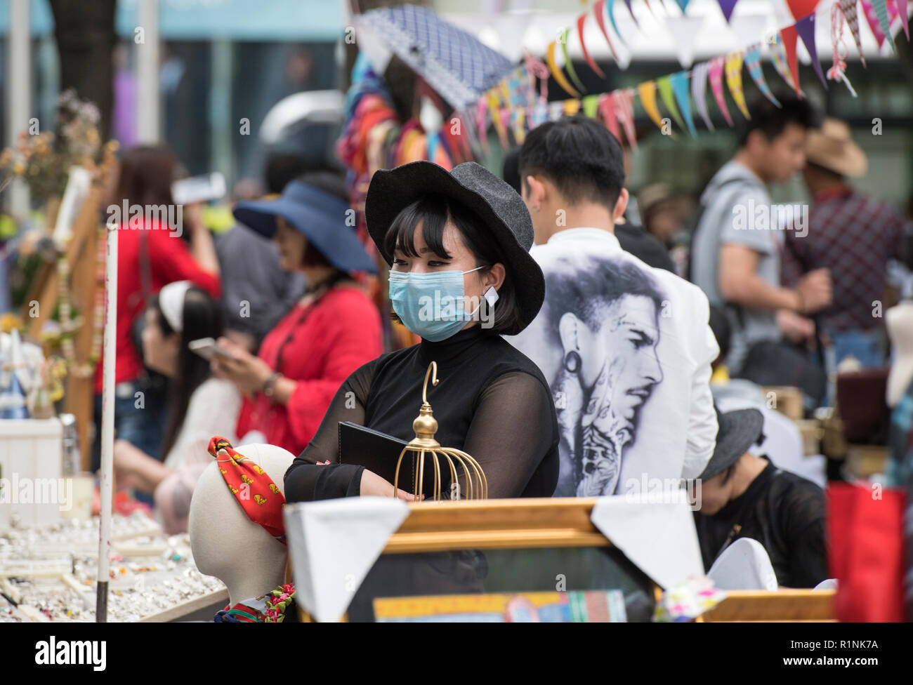 Woman wearing facial hygiene mask at a market stall in Shanghai, China ...