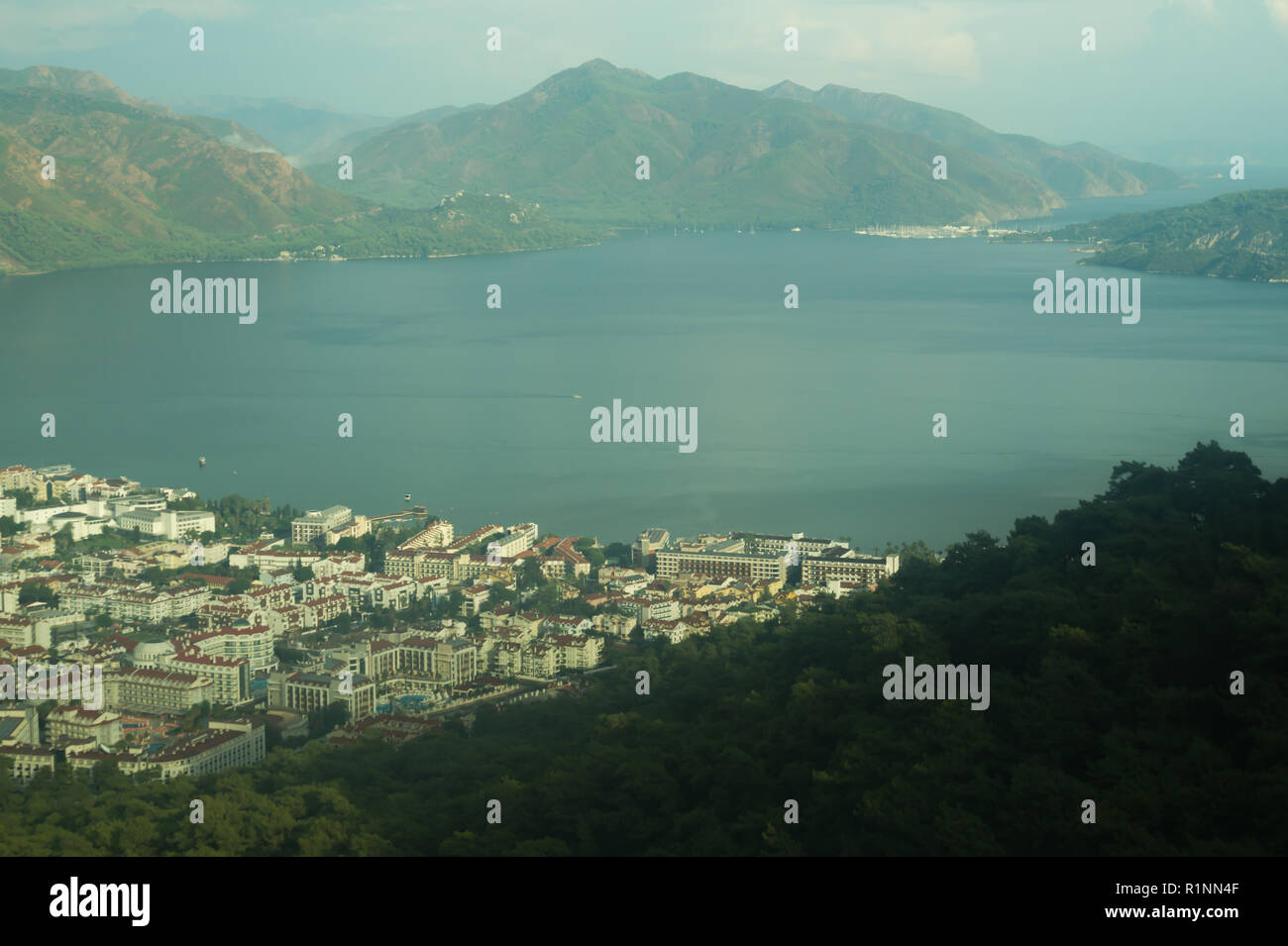 Nature landscape with a city by the shore of the sea between the hills ...