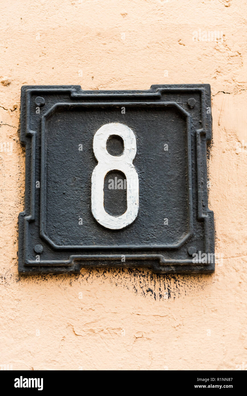 metallic house number, black on the wall Stock Photo - Alamy