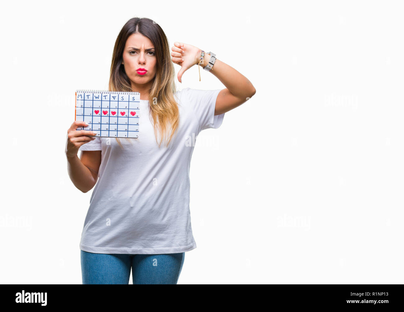Young beautiful woman holding menstruation calendar over isolated ...