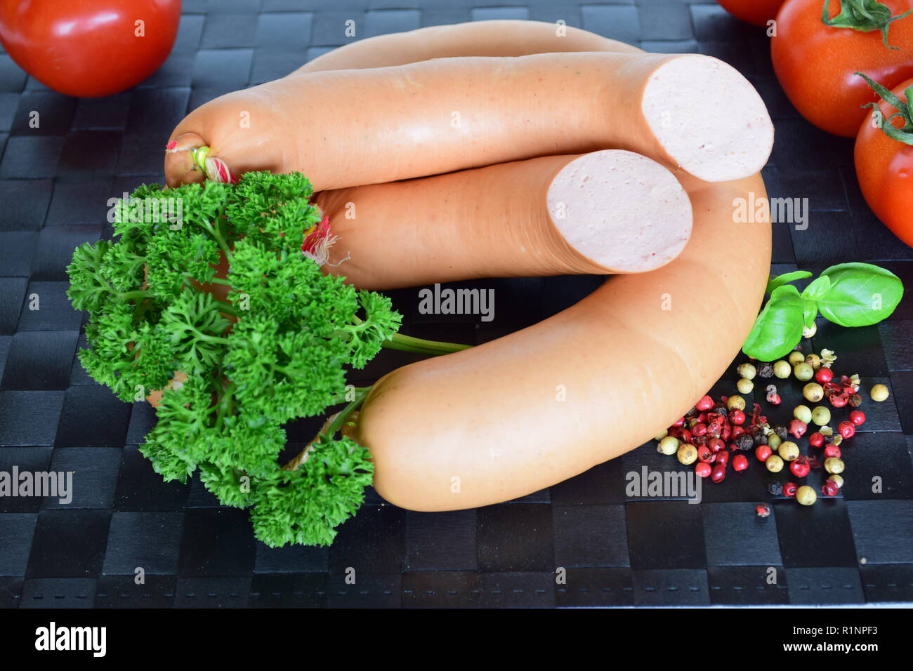 Lyoner is a Sausage delicatessen on a black placemat. Lyoner ist ein ...