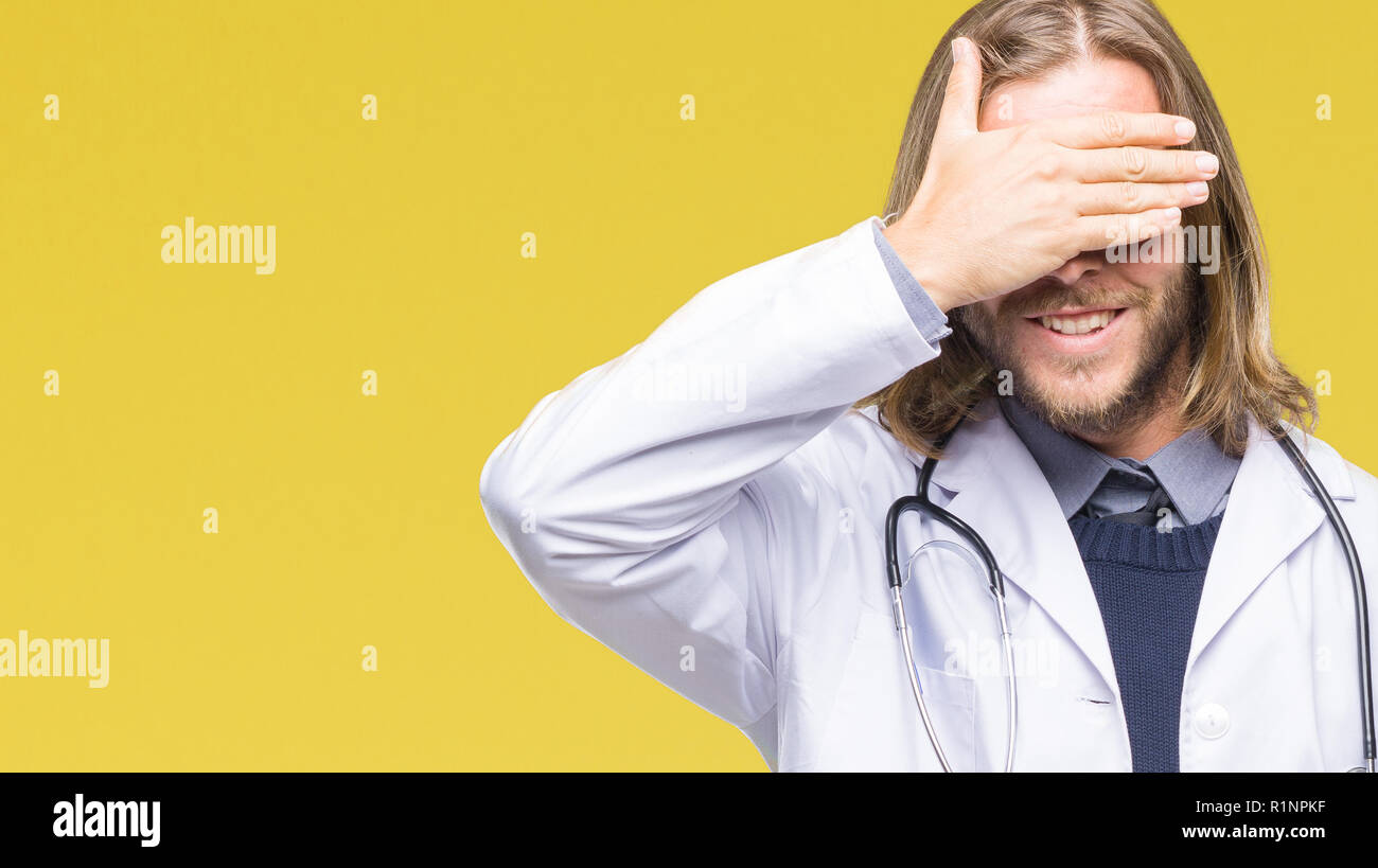Young handsome doctor man with long hair over isolated background ...