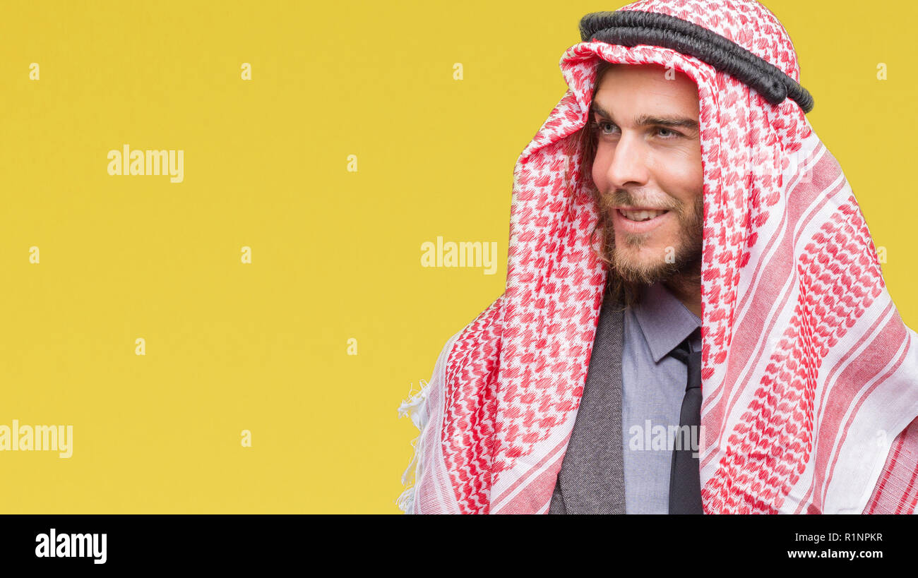 Young handsome arabian man with long hair wearing keffiyeh over ...