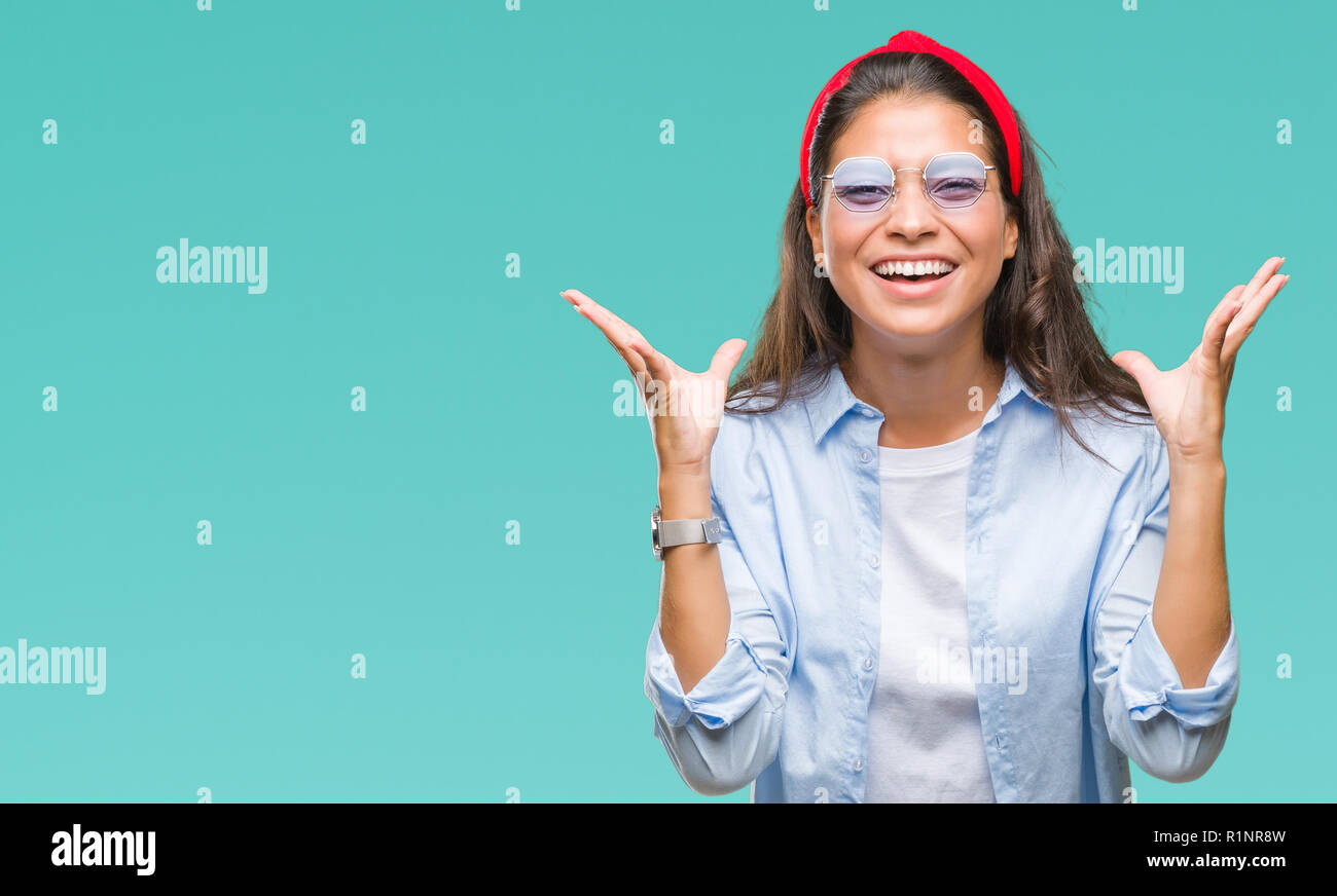Young beautiful arab woman wearing sunglasses over isolated background ...