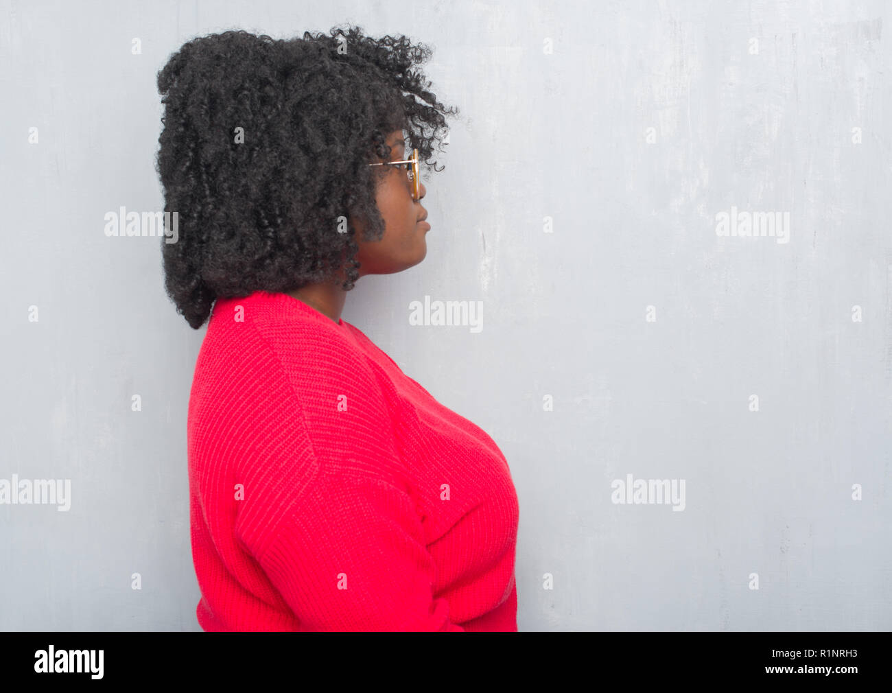 Young african american plus size woman over grey grunge wall wearing ...