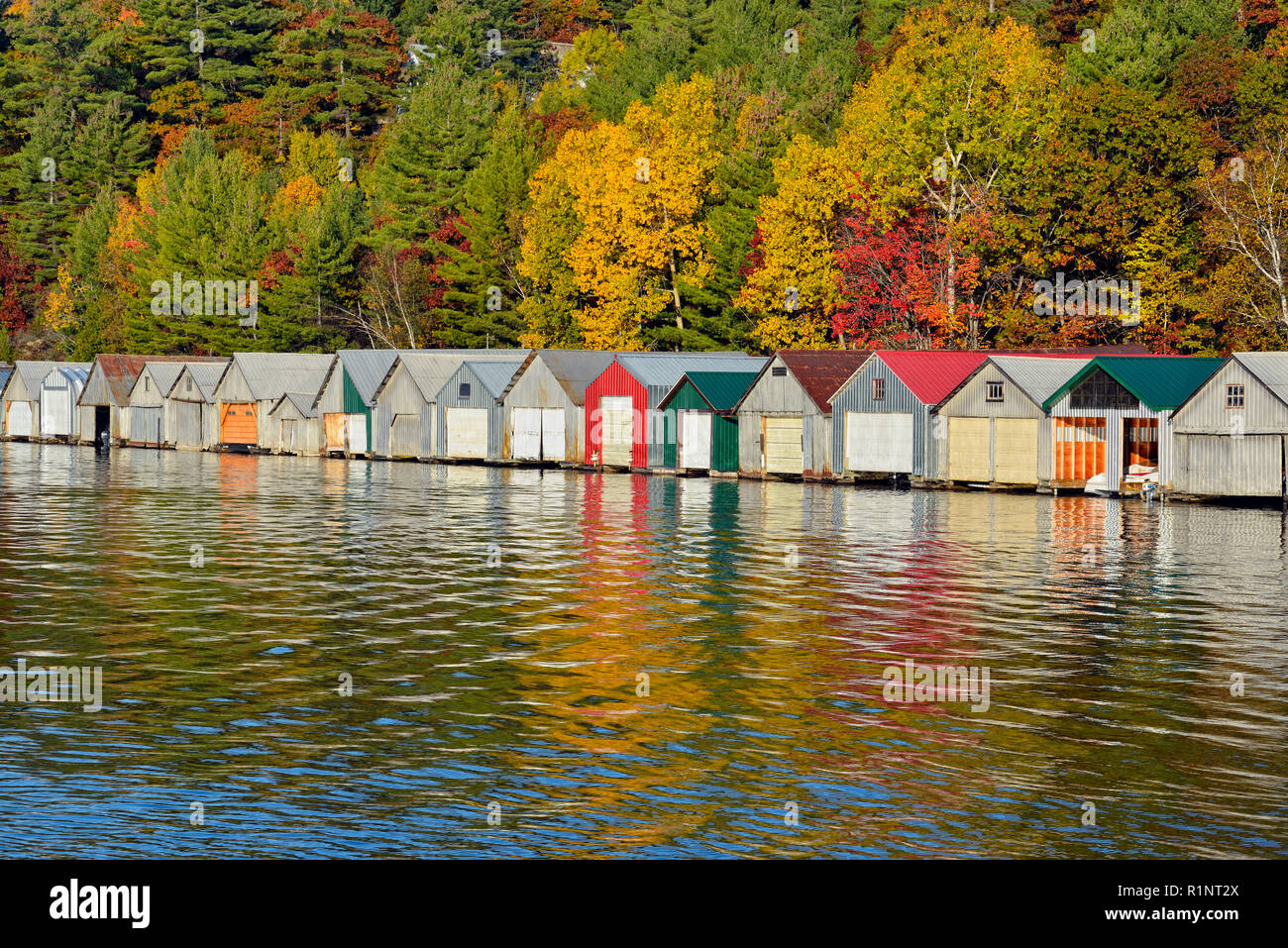 Boat houses reflected in the waters of Penage/Panache Lake at the ...