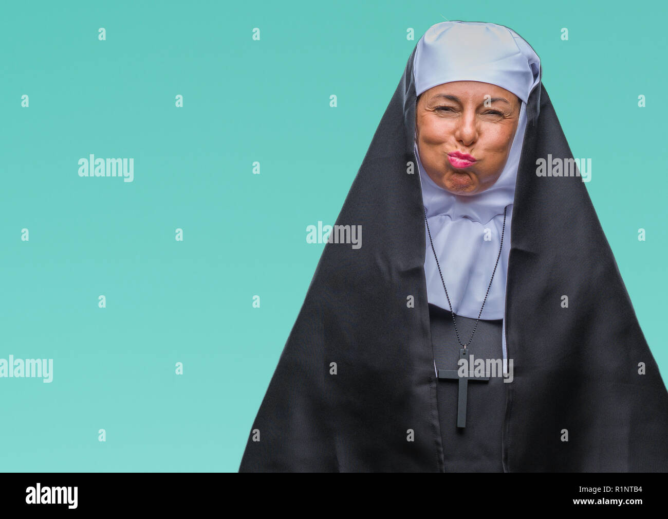 Middle age senior christian catholic nun woman over isolated background ...