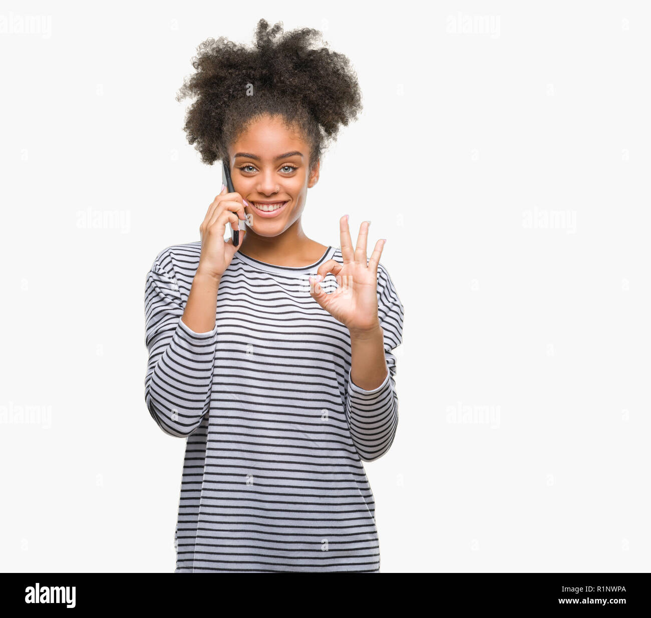 Young afro american woman talking on the phone over isolated background ...