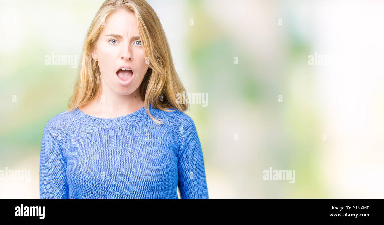 Beautiful young woman wearing blue sweater over isolated background In ...